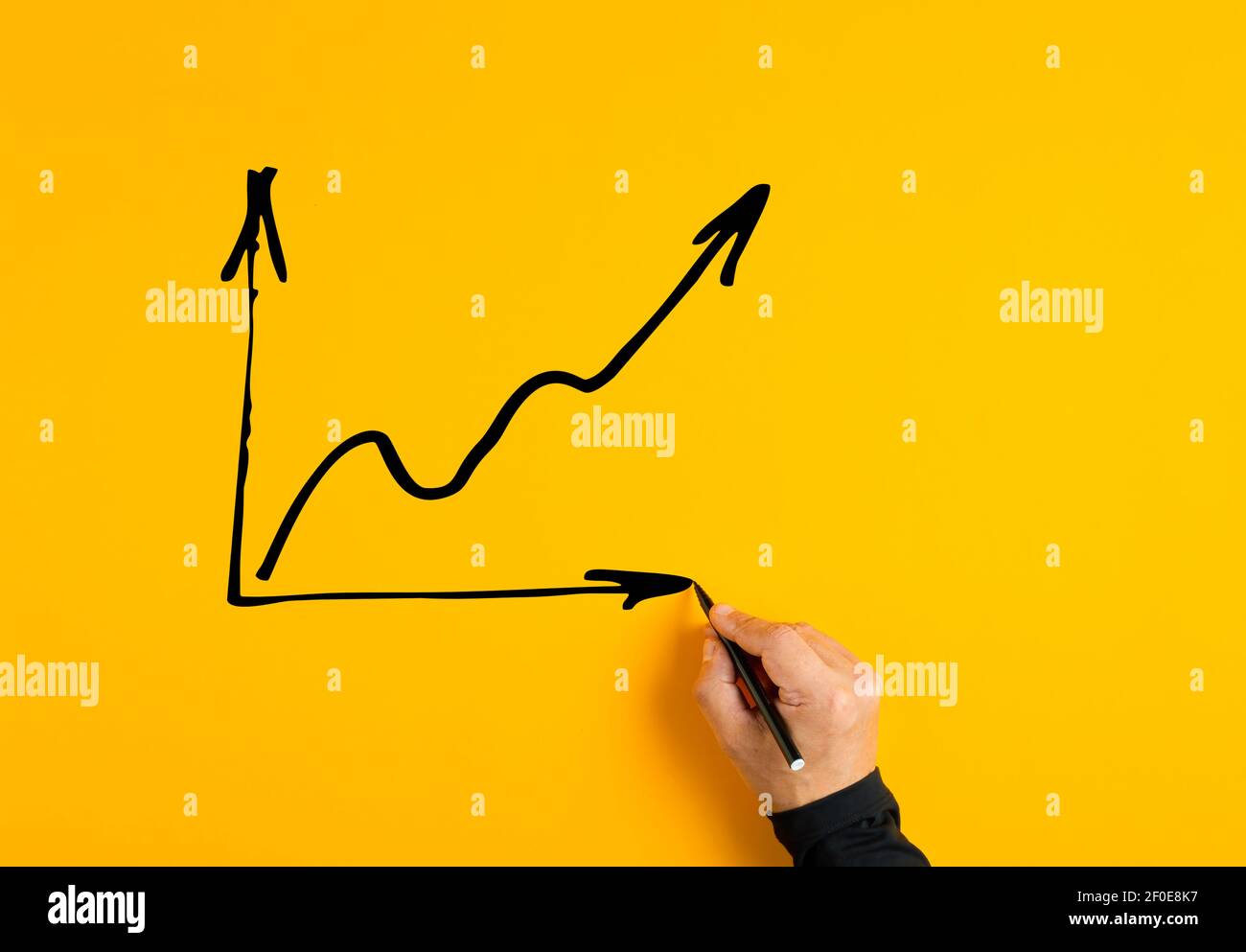 Male hand drawing a business line chart with a growing slope on yellow ...