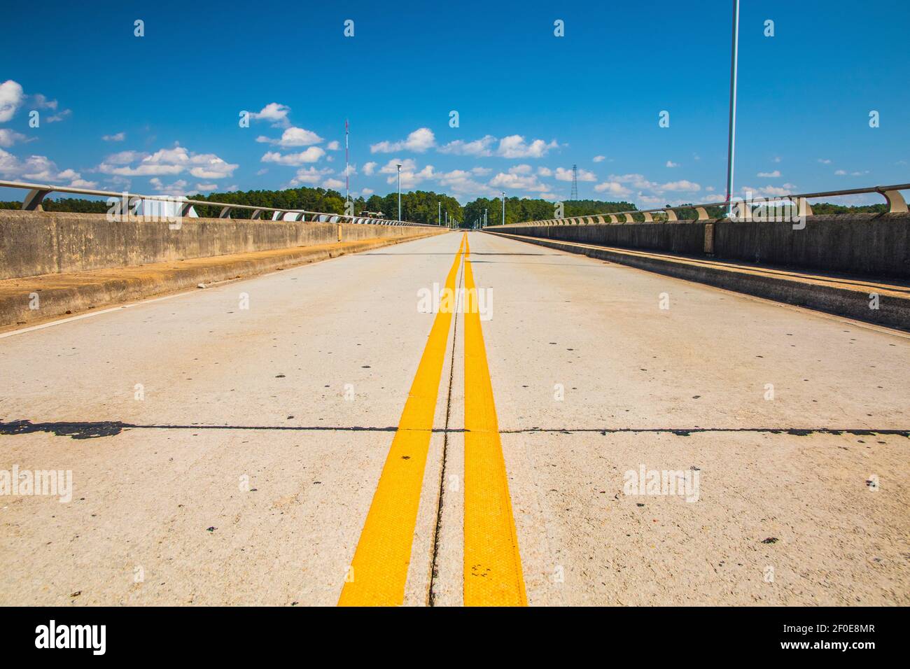 View down the yellow lines and center of a bridge road with no traffic ...
