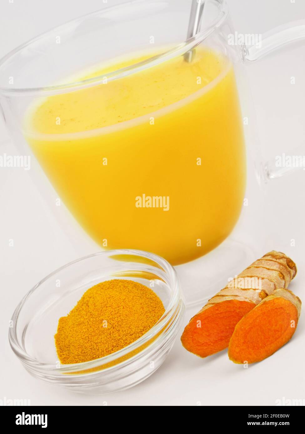 Milk with curcuma against white background Stock Photo - Alamy