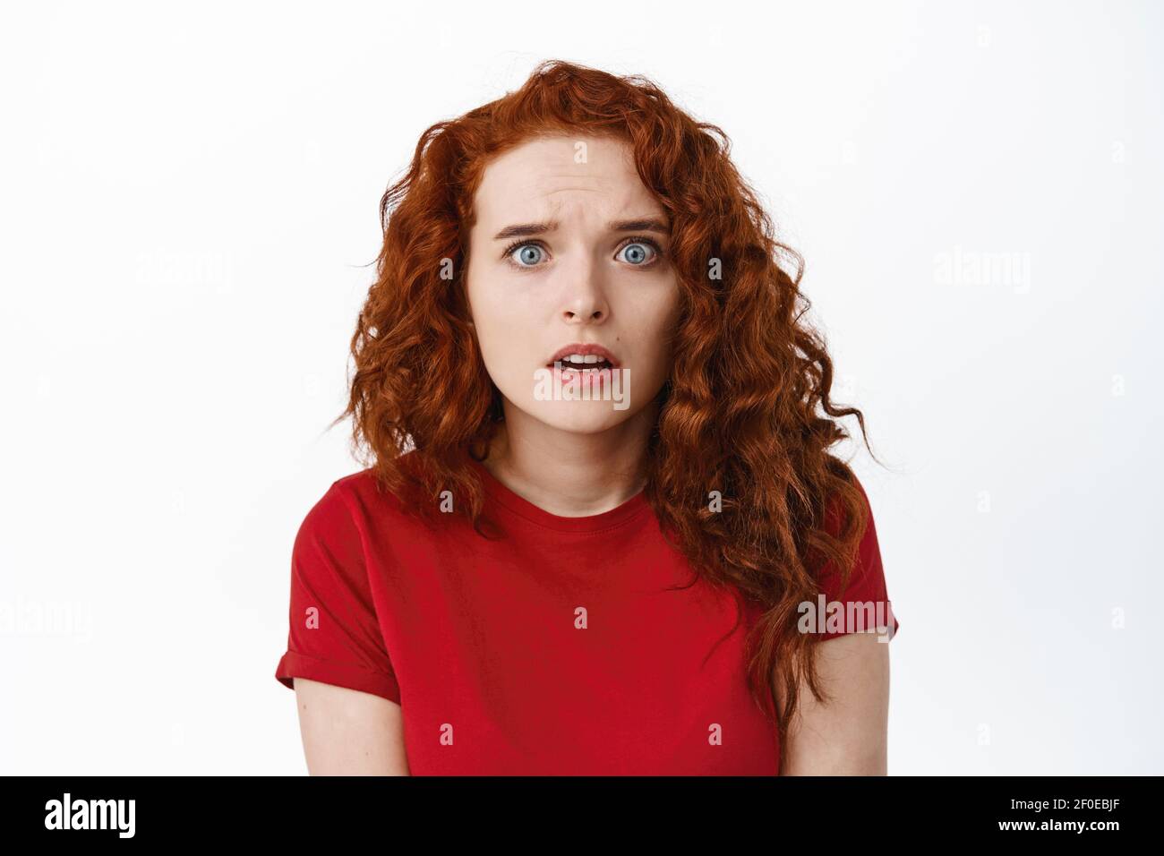 Portrait of worried and concerned ginger girl looking at camera anxious ...