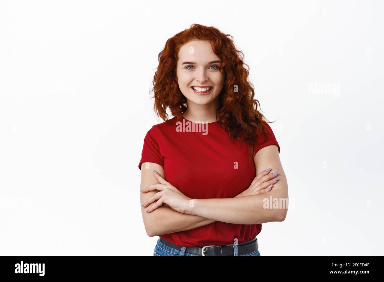 Portrait of determined happy redhead woman with curly hair, cross arms ...