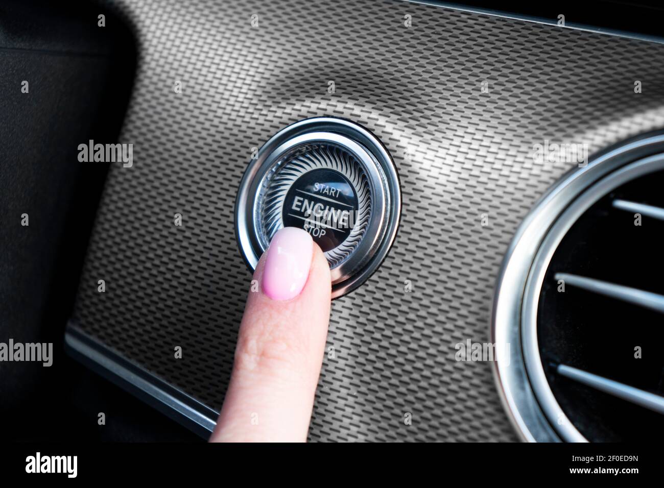 Car driver starting the engine with start stop engine button. Finger ...