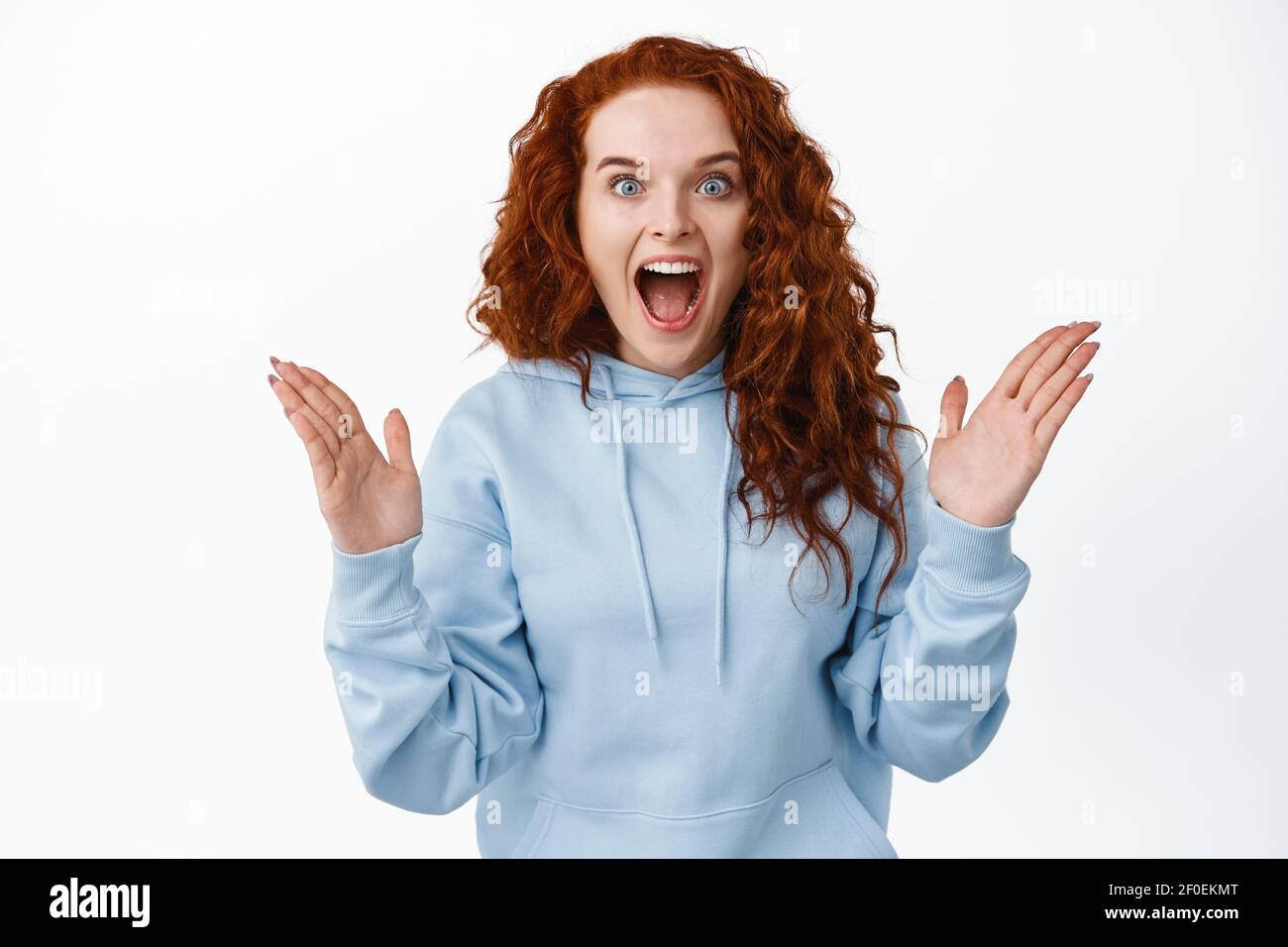 Image of redhead girl screaming from surprise and amazement, shouting ...