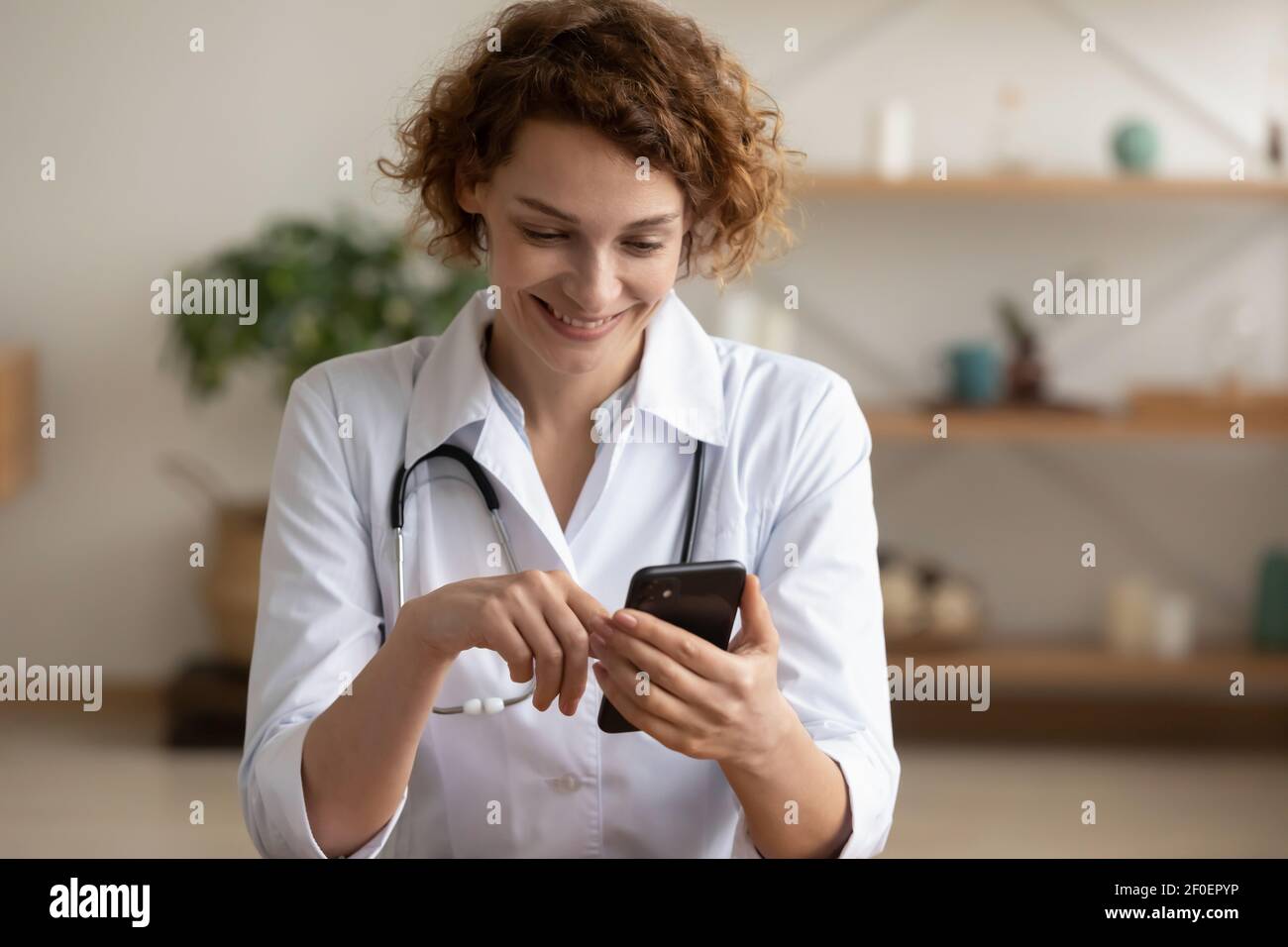 Smiling female nurse use cellphone for online video call Stock Photo ...