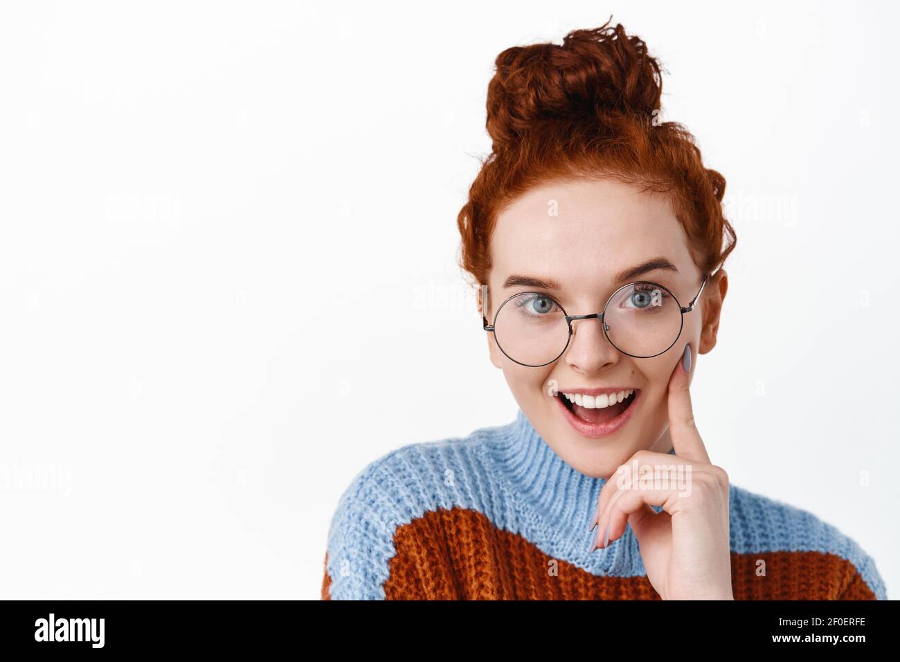 Beautiful ginger girl student in glasses look with amazement and joy at ...