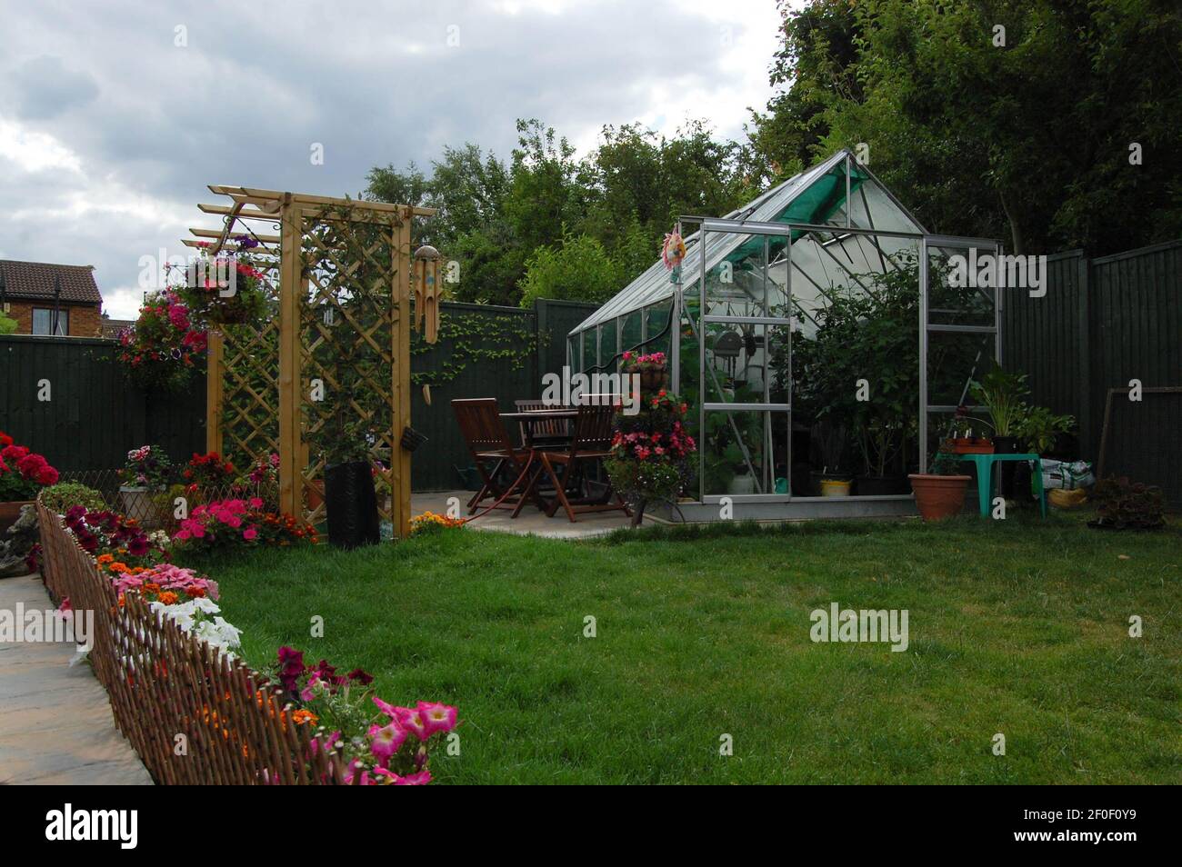 Greenhouse in Garden grass path paving stones fence fencing tree trees ...