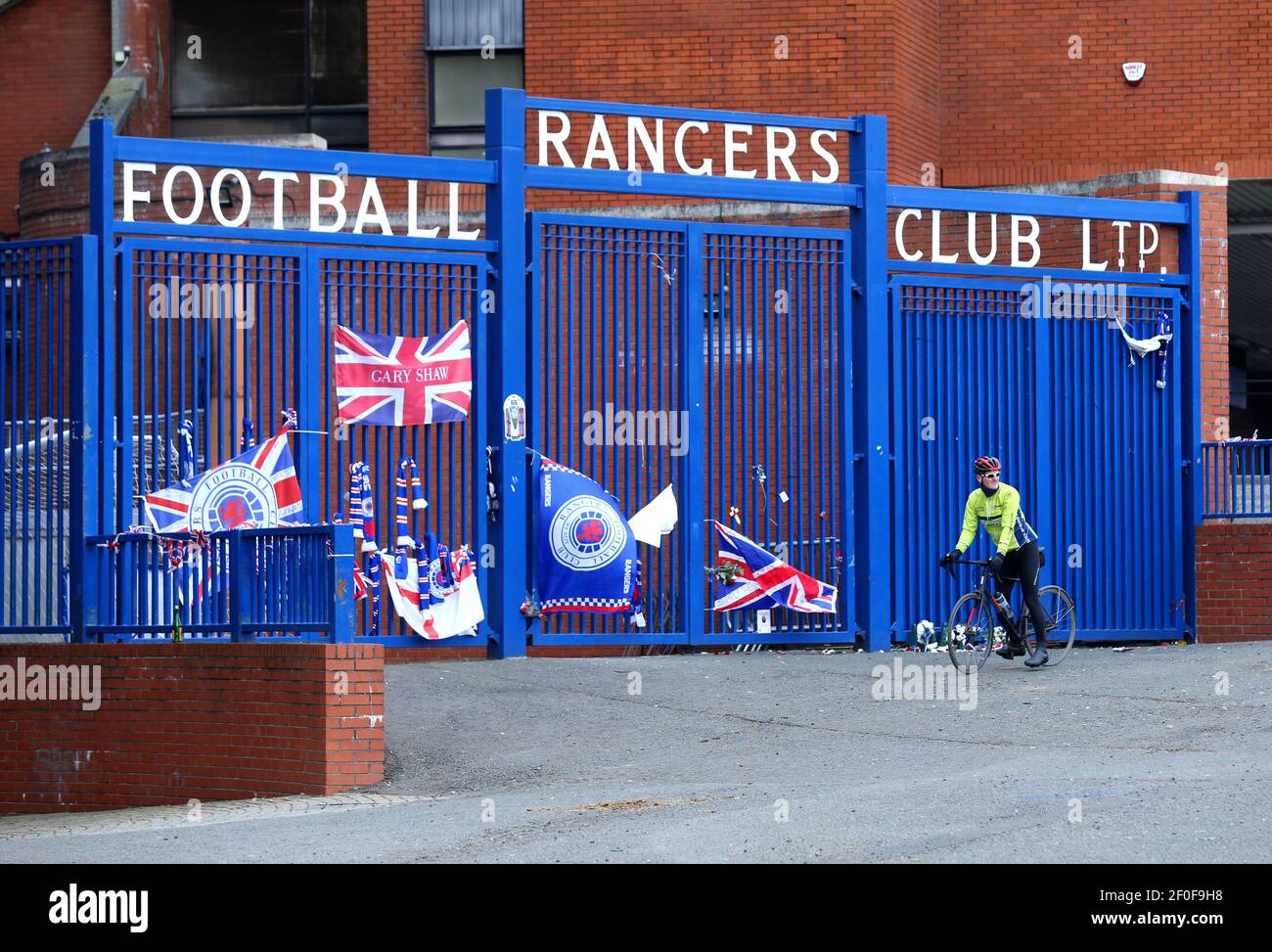 A cyclist stops outside the gates of the Ibrox Stadium, home of Rangers ...