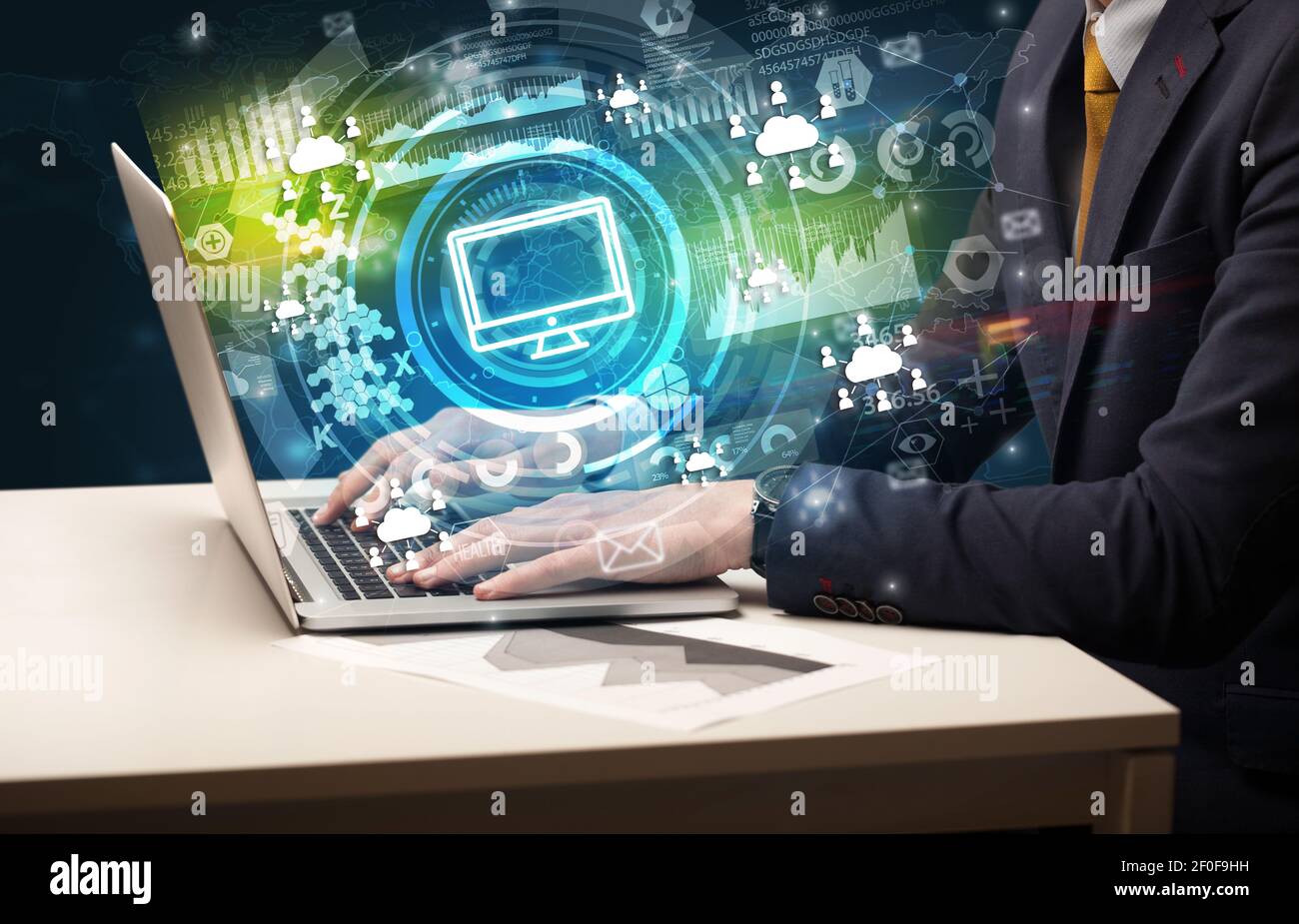 Business hand typing on a modern laptop with display icon coming out ...