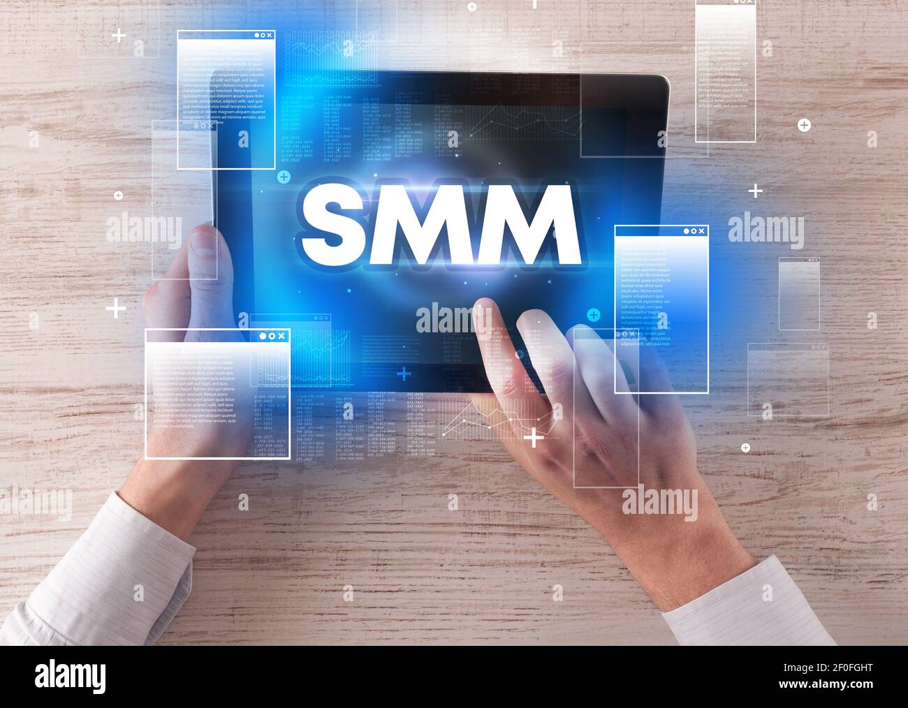 Close-up of a hand holding tablet with SMM abbreviation, modern ...