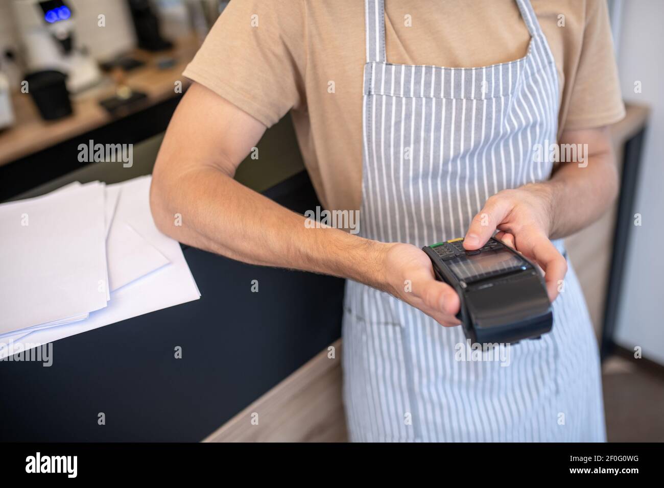 Male hands holding pos terminal pressing button Stock Photo - Alamy