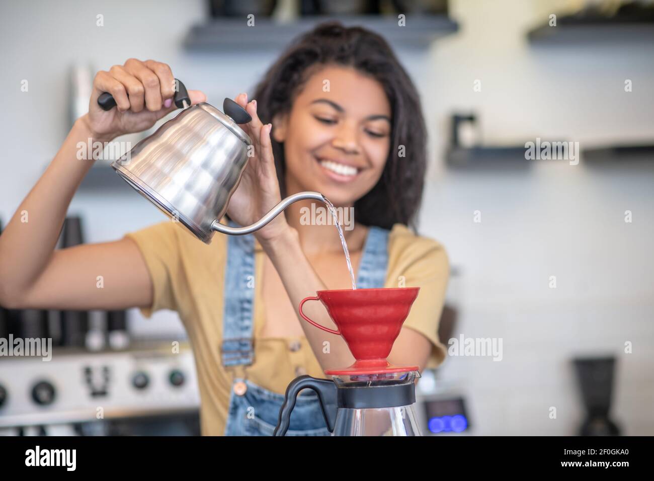 Concentrated woman brewing coffee using dripper Stock Photo - Alamy