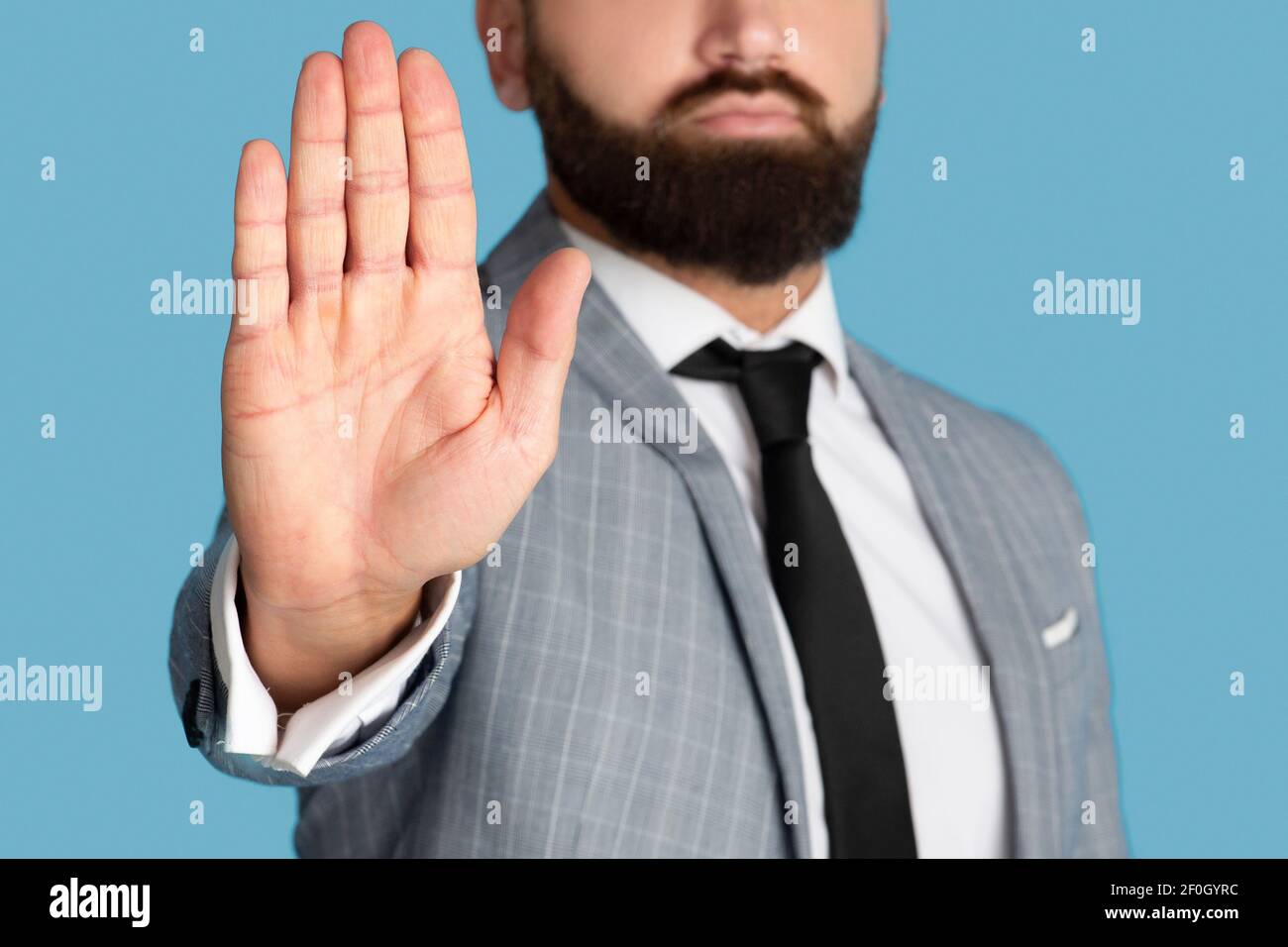 Cropped view of millennial businessman refusing something, showing STOP ...