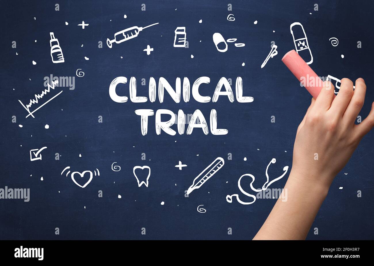 Hand drawing CLINICAL TRIAL inscription with white chalk on blackboard ...
