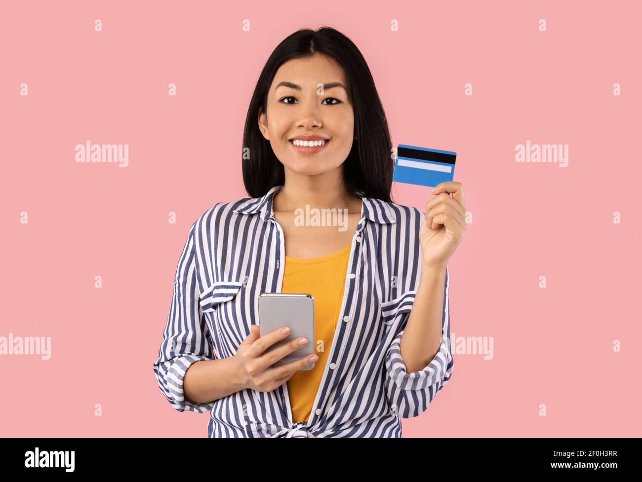 Young asian woman holding credit card and smartphone Stock Photo - Alamy