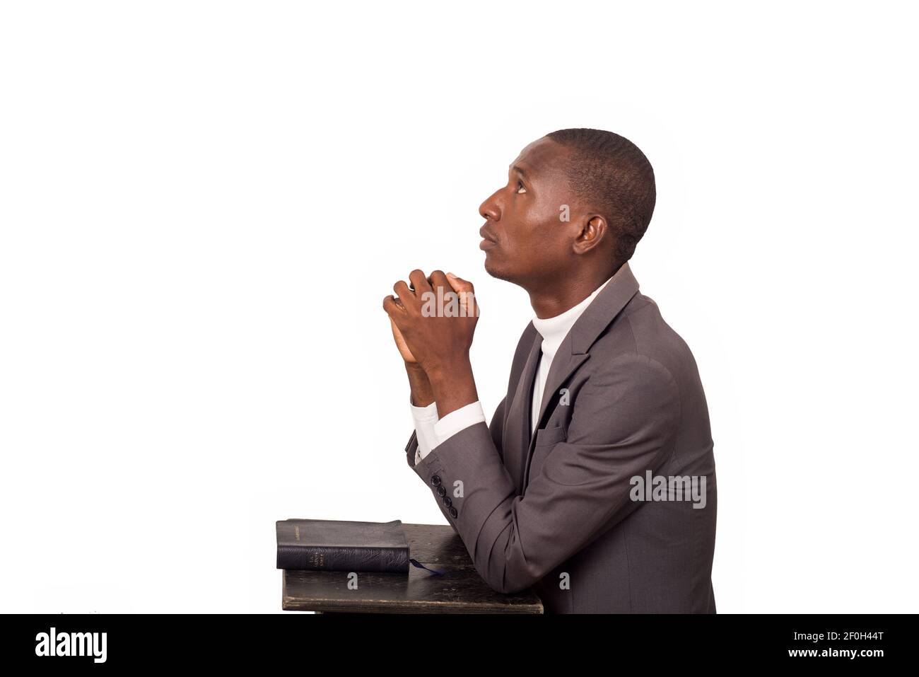 portrait of young pastor kneeling and praying head up Stock Photo - Alamy