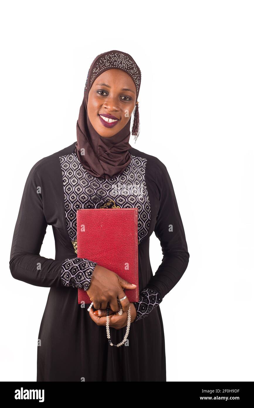 portrait of young muslim woman standing and holding a religious ...
