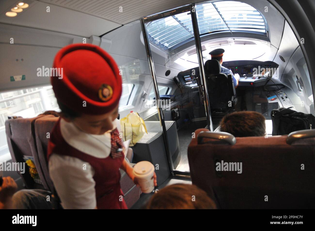 A hostess is waiting at 1st class passengers, right behing the train ...