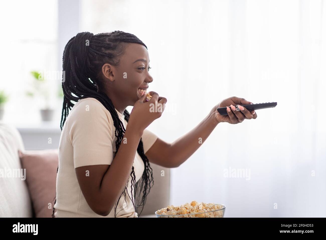 Side view of african american woman watching TV Stock Photo - Alamy