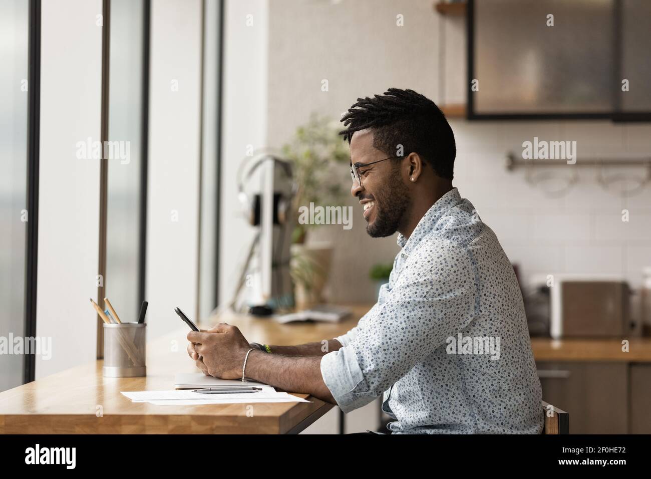 Side View Smiling African American Man Wearing Glasses Using Smartphone
