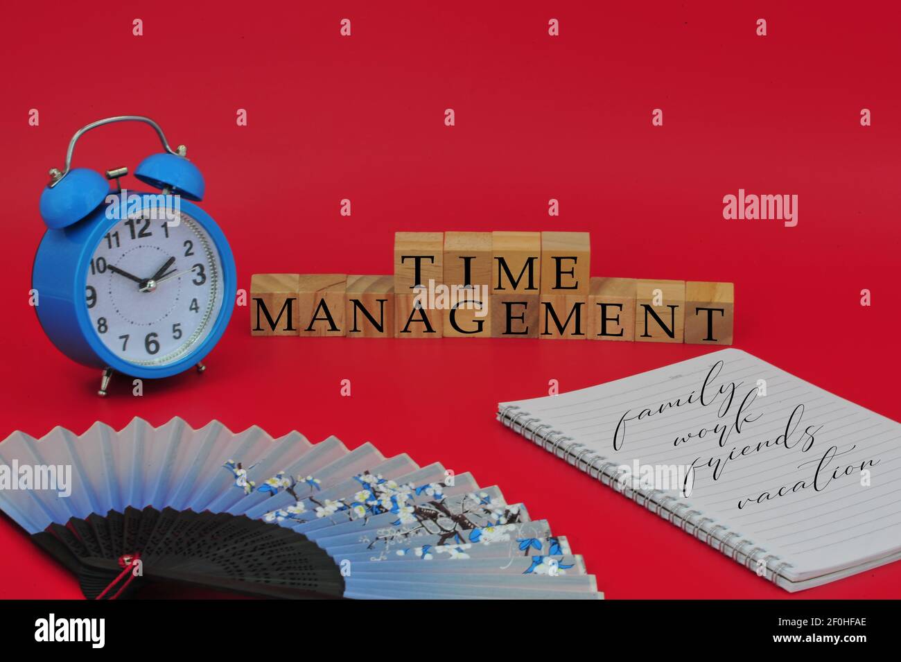 Layout of alarm clock, note book, fan and wooden cube with text TIME ...