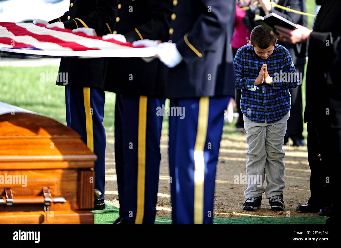 Charlie Salerno, 8, of New York bows his head as members of the United ...