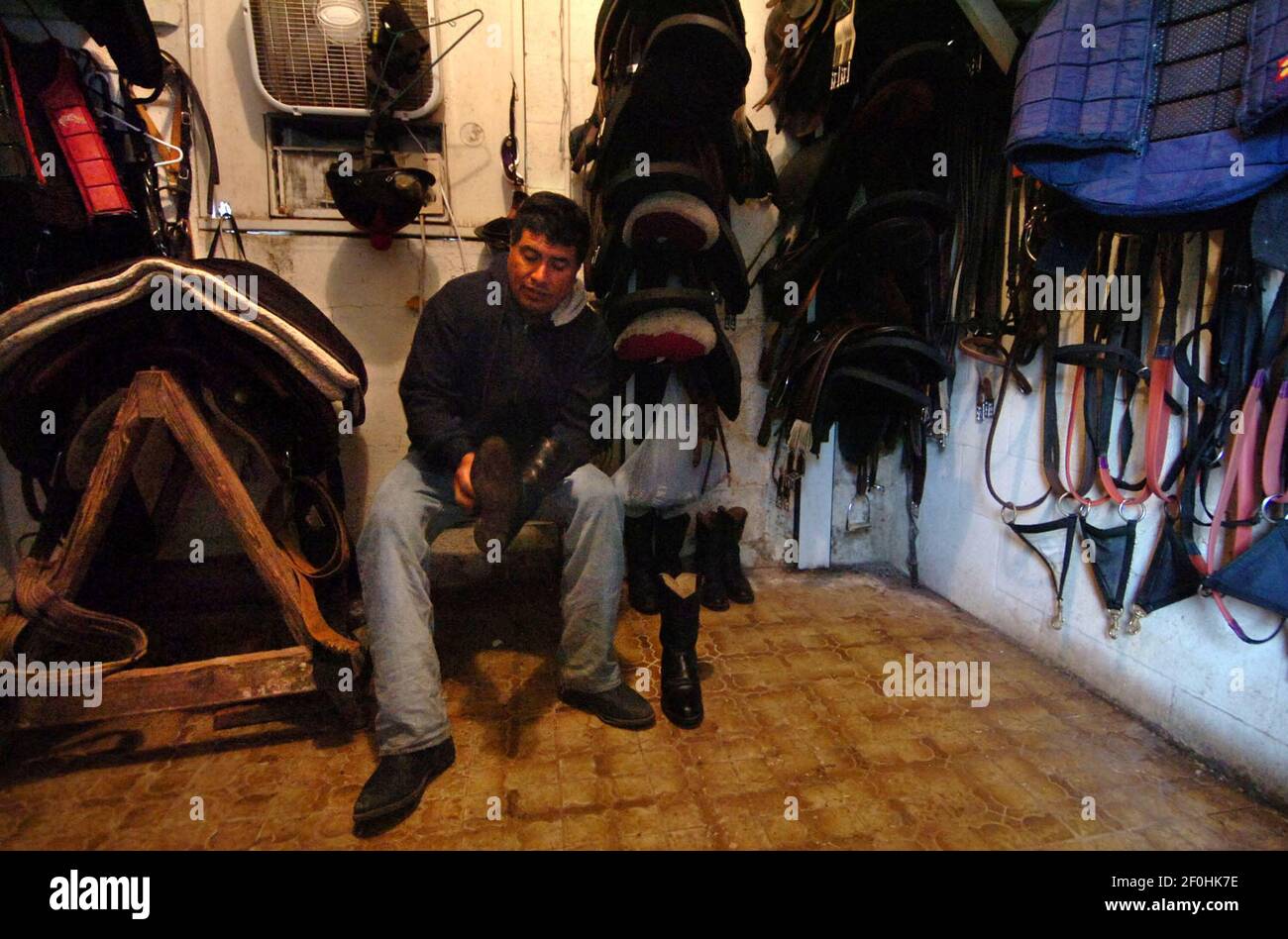 Moises Alvarado, 45, cleans his boots in the tack room before he wears ...
