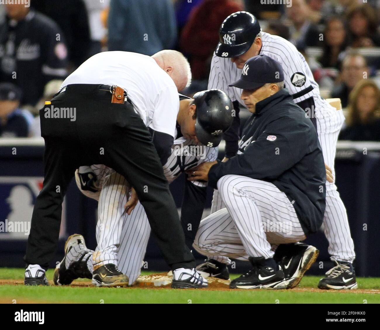 New York Yankees manager Joe Girardi and a trainer look at Mark ...