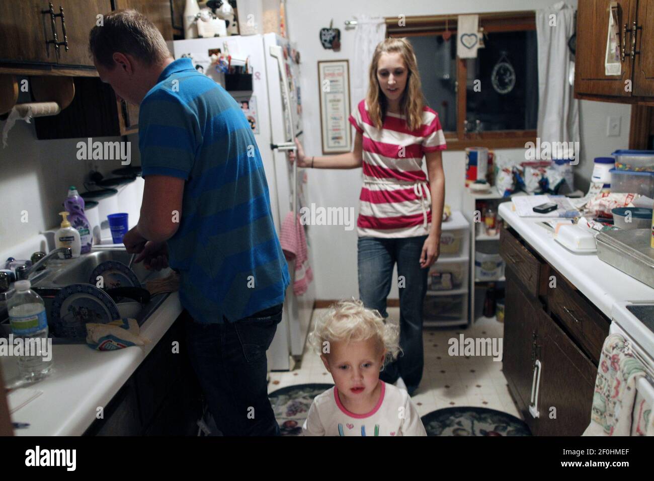 Andrew Demeny, Jessica Peltier and her daugheter, Kiley, prepare dinner ...