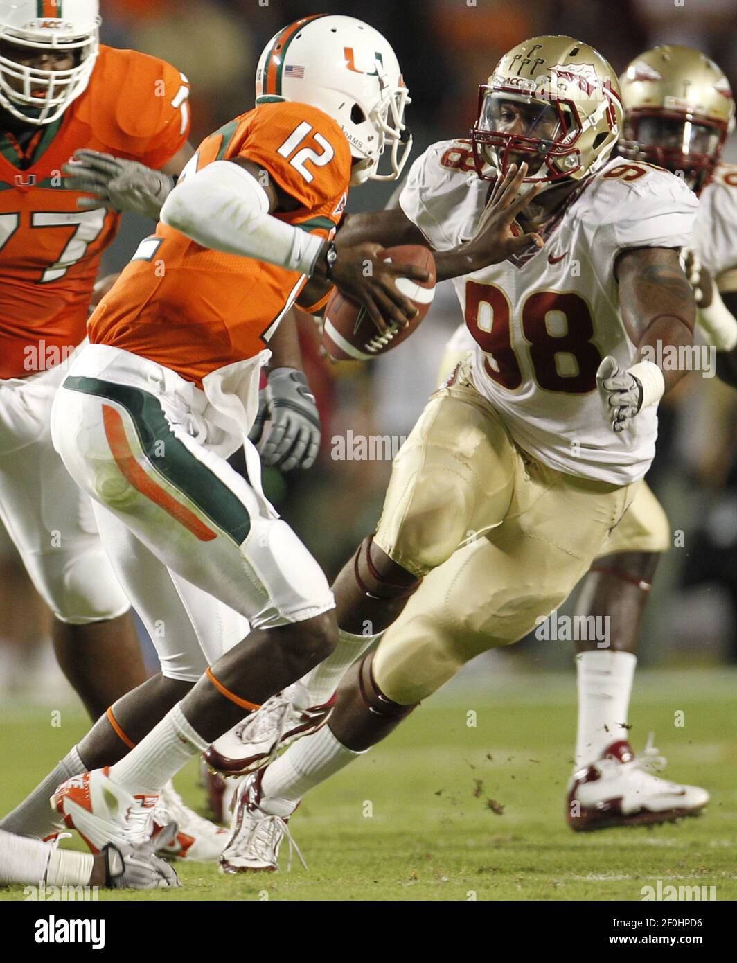 Miami quarterback Jacory Harris (12) is sacked by Markus White, right ...