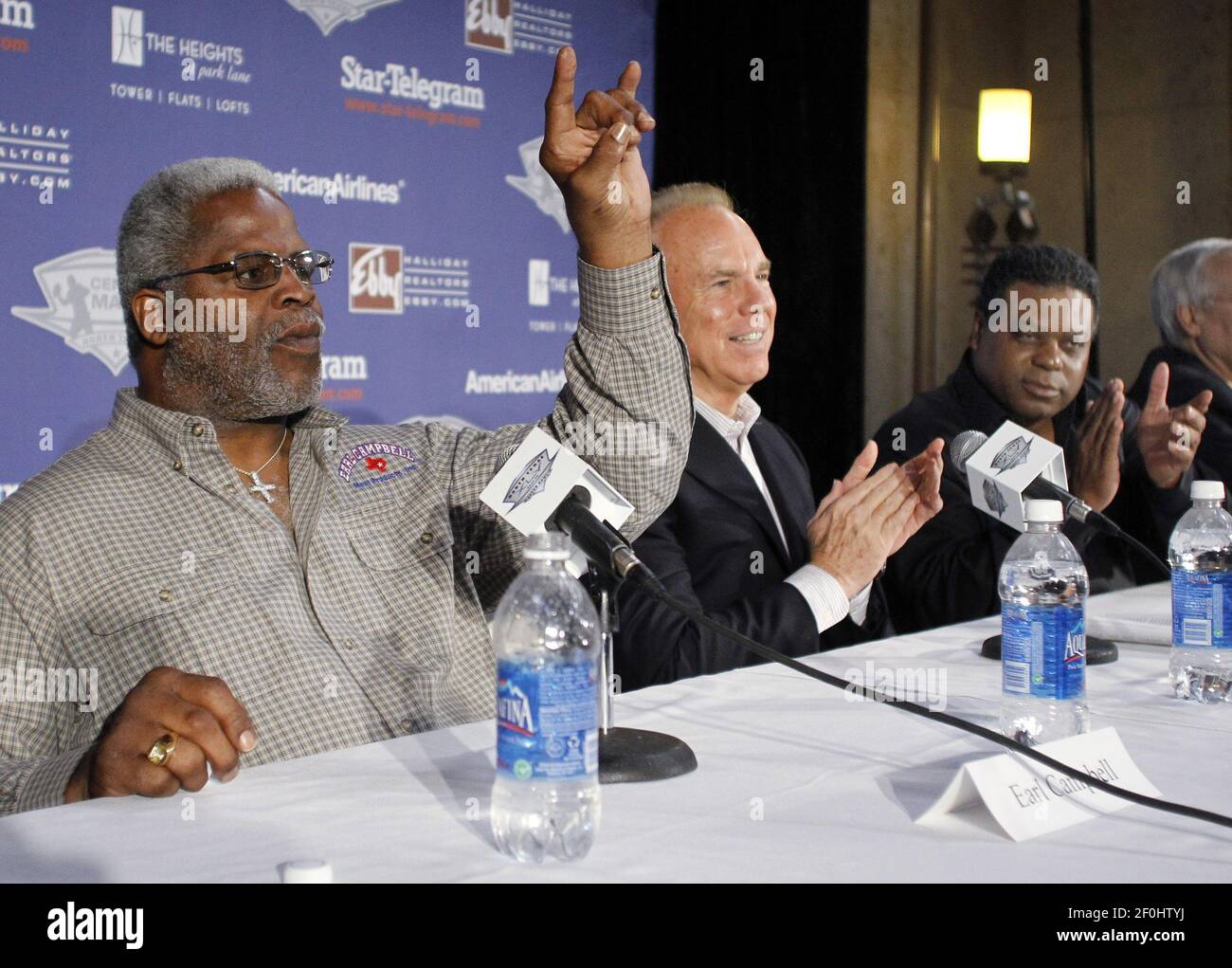 Earl Campbell, left, flashes the Hook 'em Horns sign as he is ...