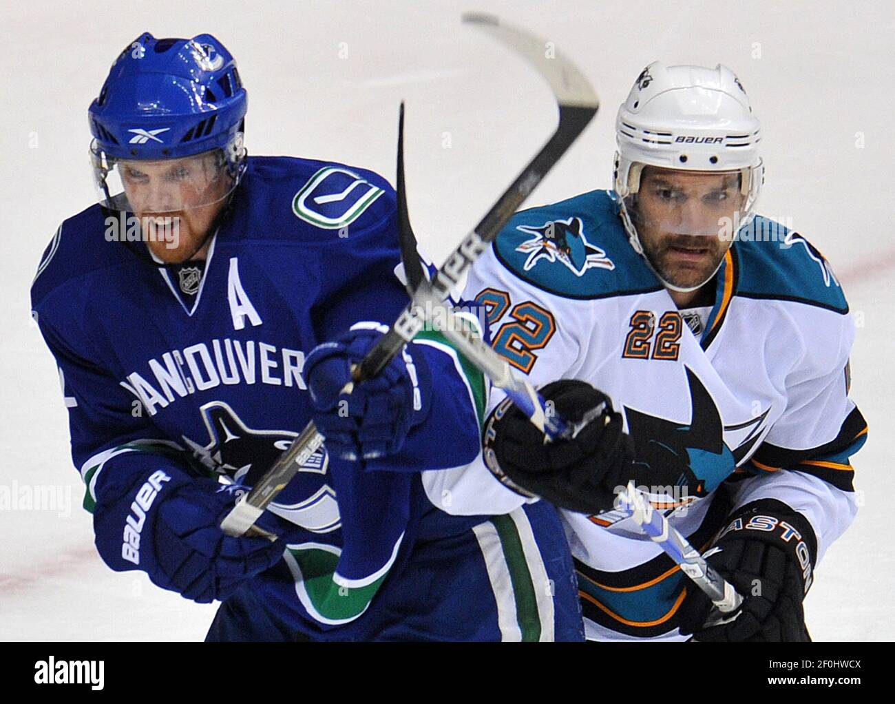 Vancouver Canucks' Daniel Sedin, left, crosses sticks with San Jose ...