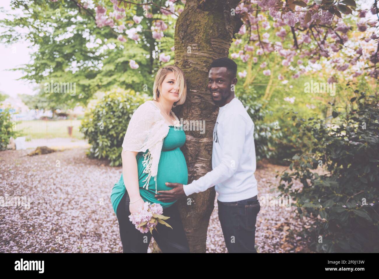 Pregnant couple - father hugging mommy bump Stock Photo - Alamy