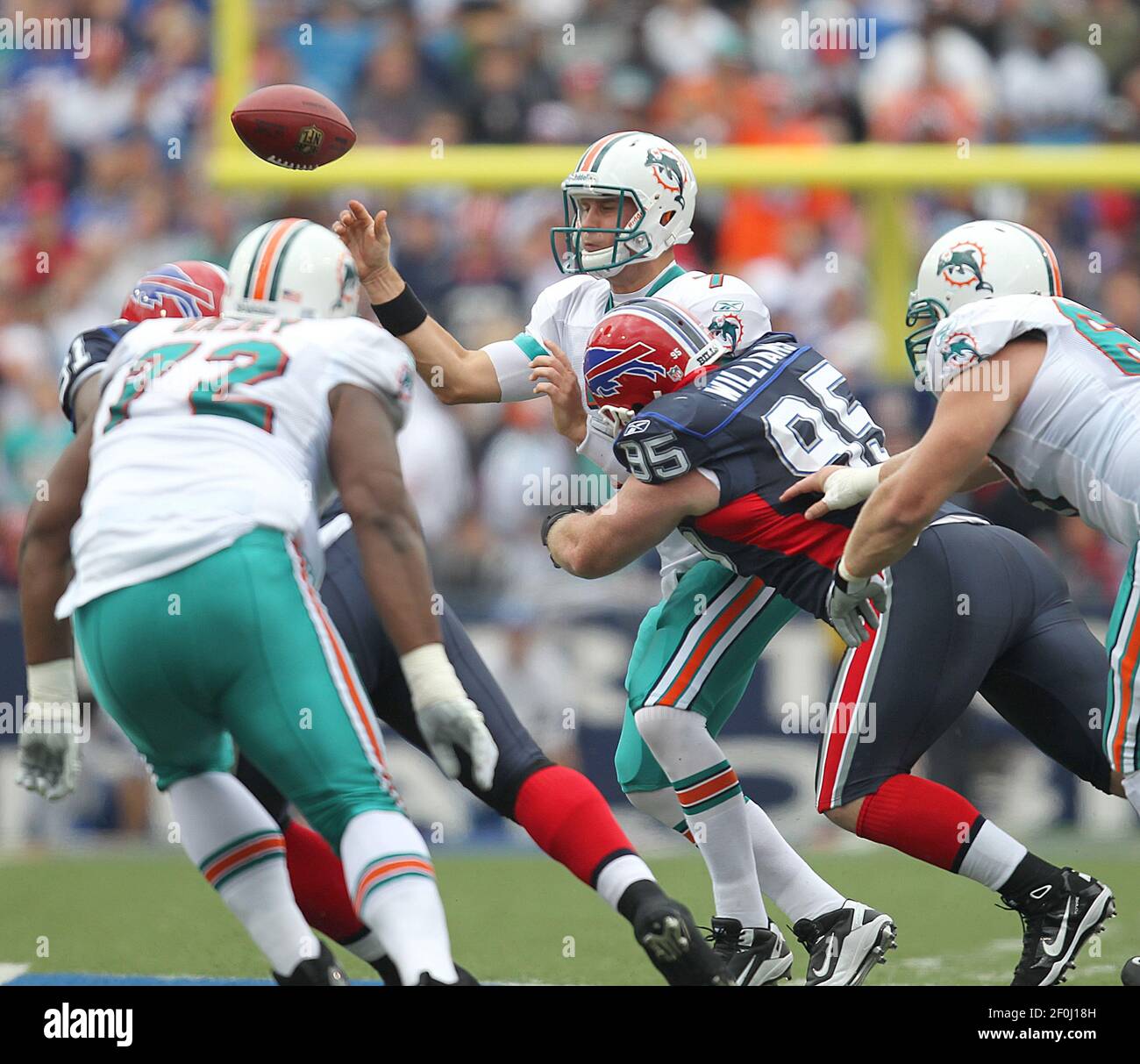 Miami Dolphins quarterback Chad Henne throws a pass while in the grasp ...