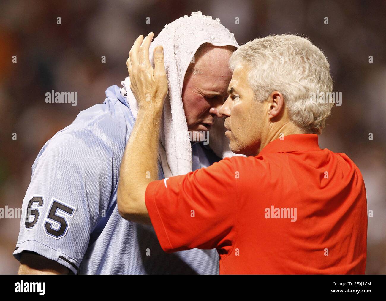 Home Plate umpire Ted Barrett gets cooled off with an icy towel by a ...