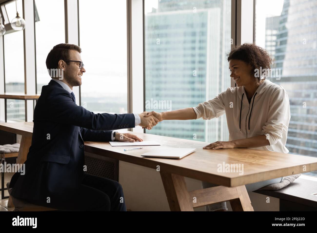 Side view smiling hr manager shaking African American woman hand Stock ...