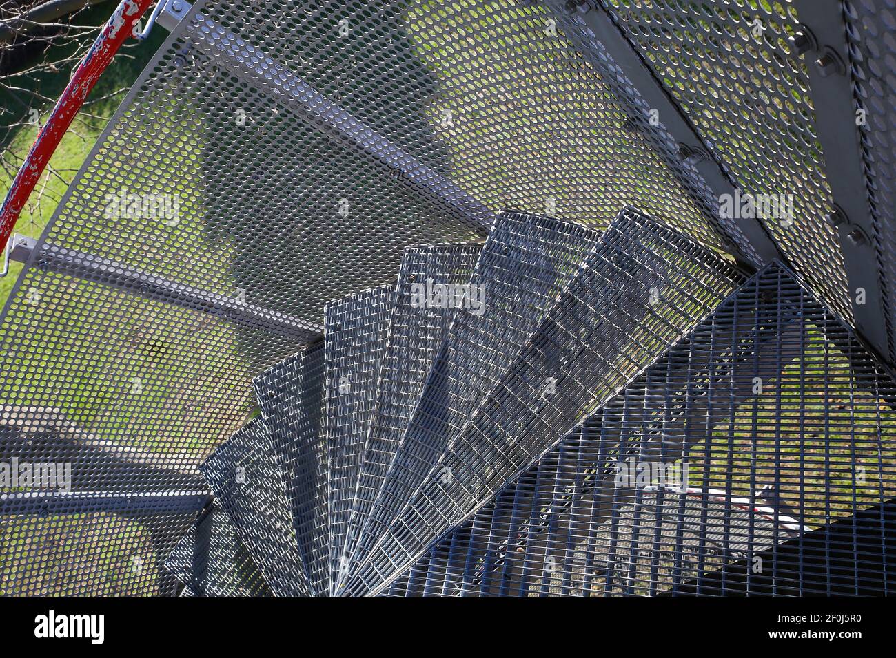 View down on narrow tight outdoor steep spiral steel staircase with ...