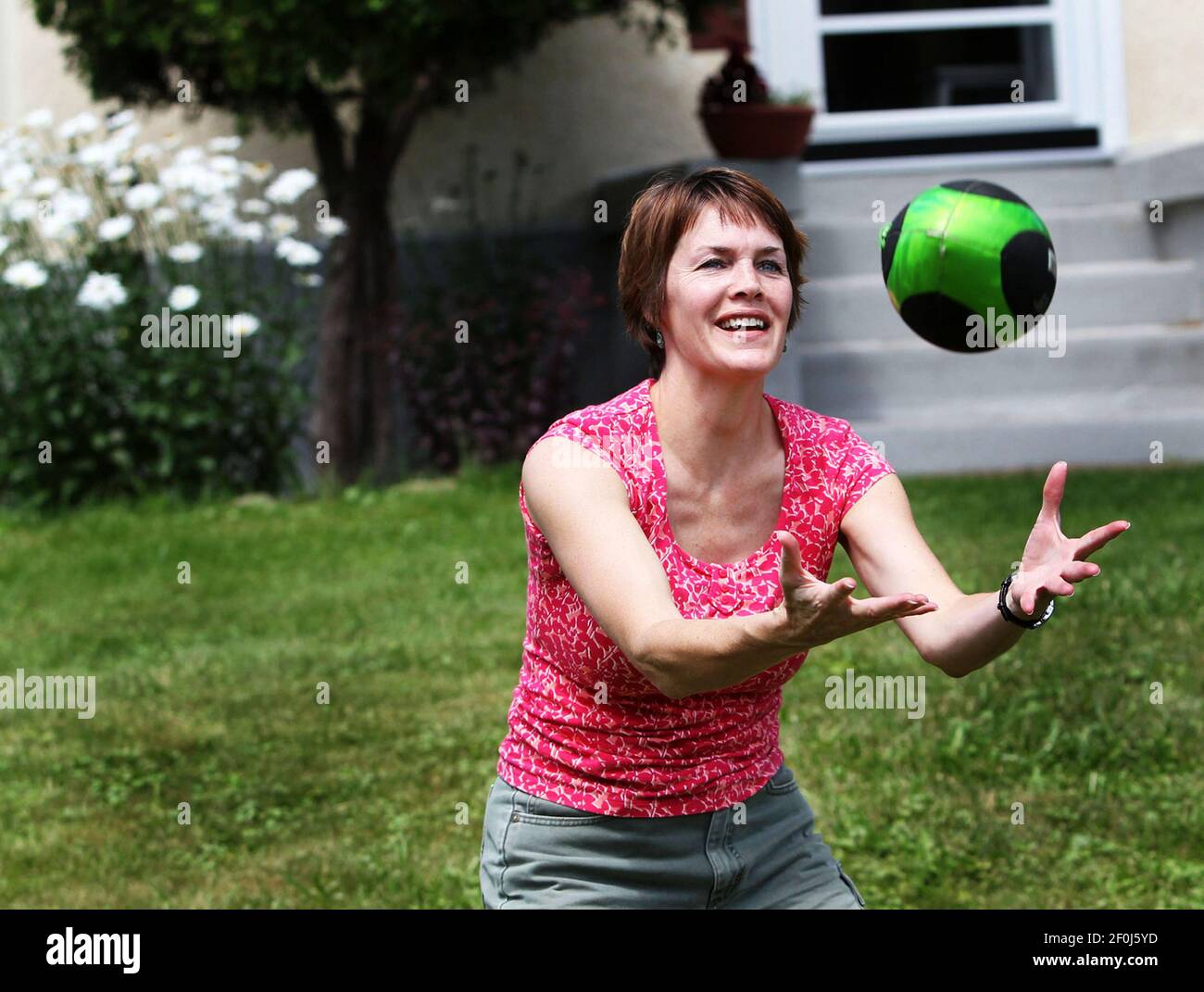 Amy Leyden throws a football to her 12-year-old son Luke Schroeder in ...