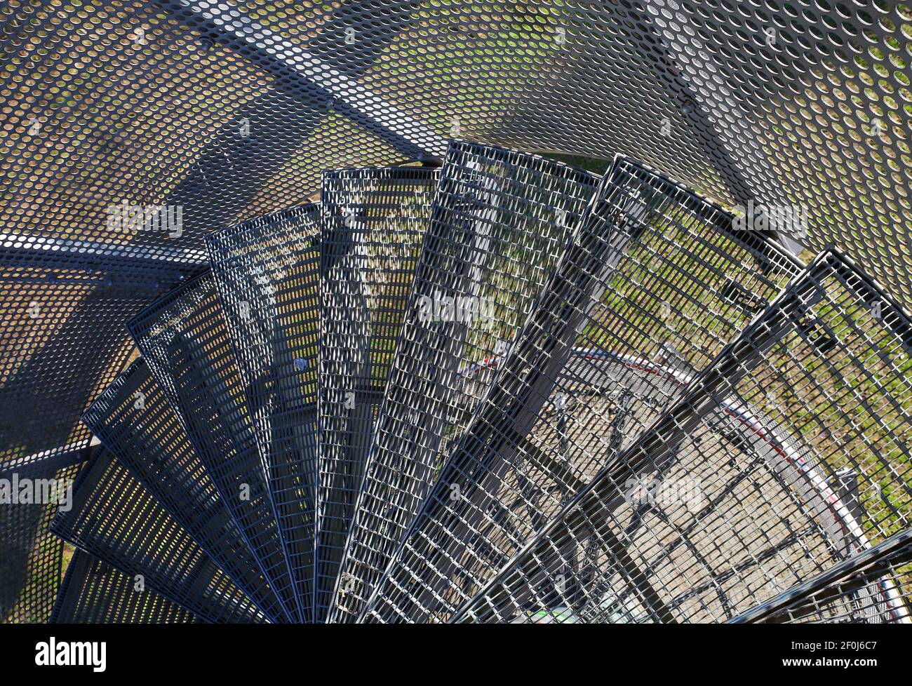 View down on narrow tight outdoor steep spiral steel staircase with ...