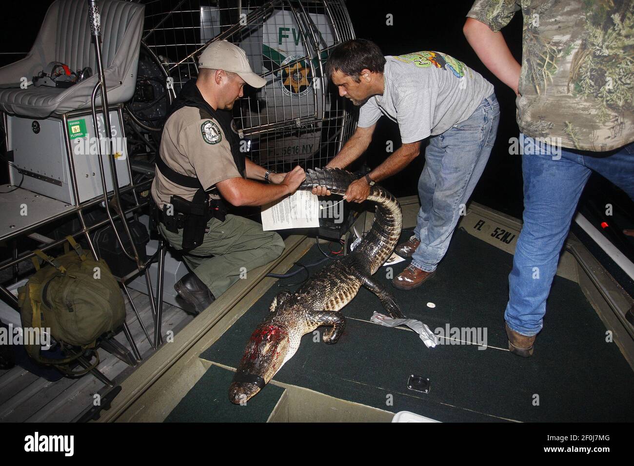 A Florida wildlife officer checks the tag shown by guide Bobby Stafford ...