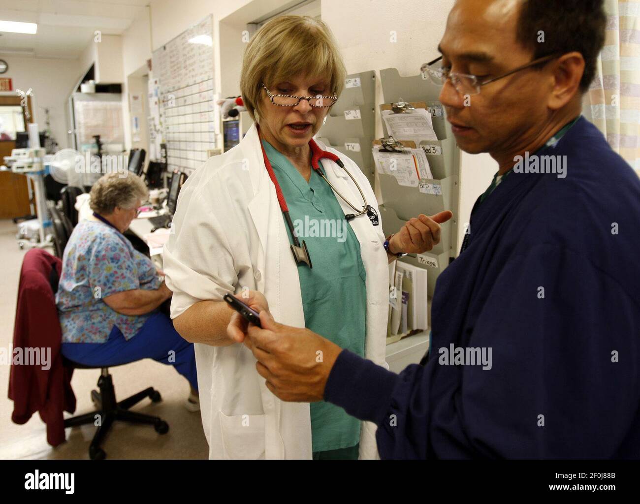 Dr. Kathy Corby, center, shows her iPhone 4 to anesthesiologist Pat ...
