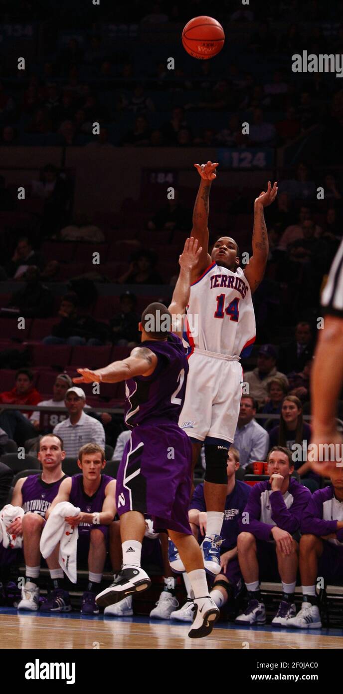 Travis Nichols of St. Francis College shoots over Michael Thompson of ...