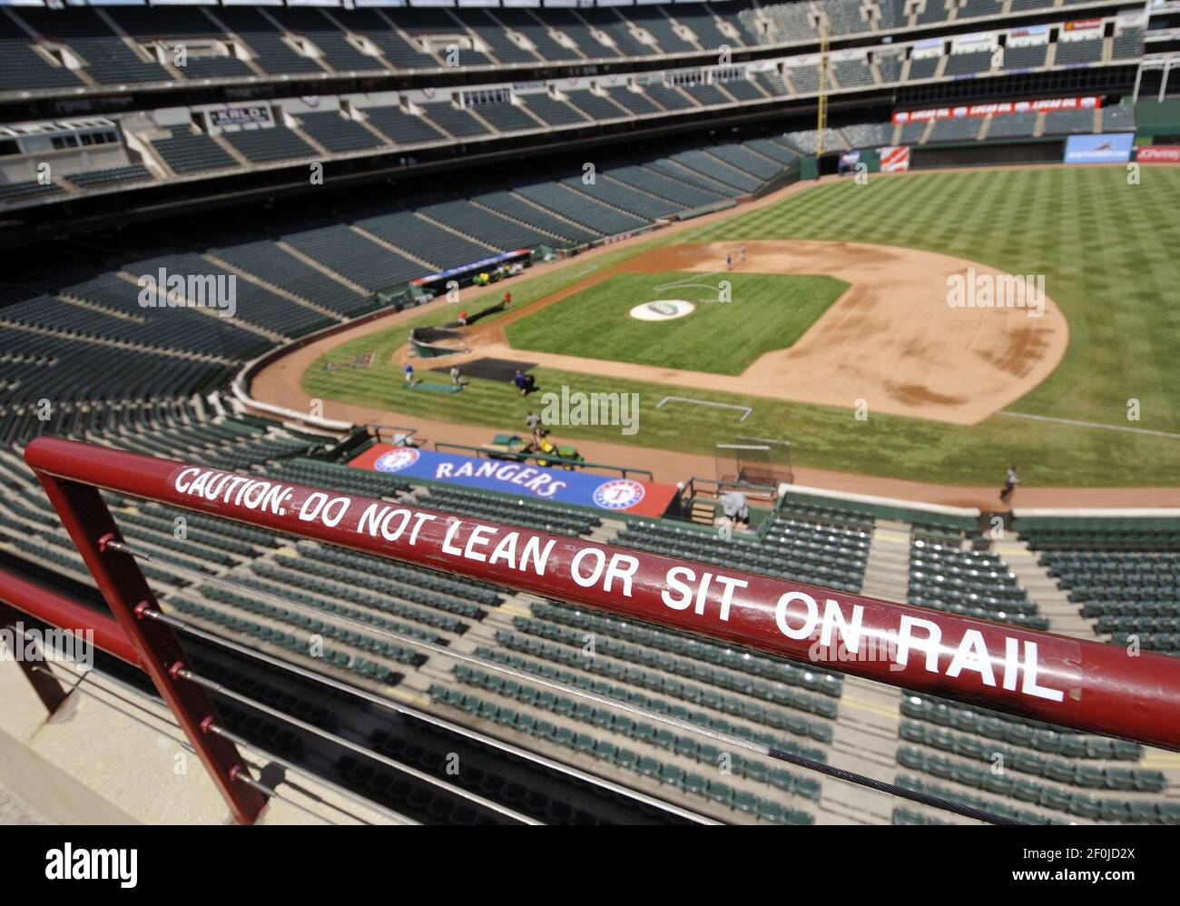 A caution sign adorns a railing on the Club Level at Rangers Ballpark ...