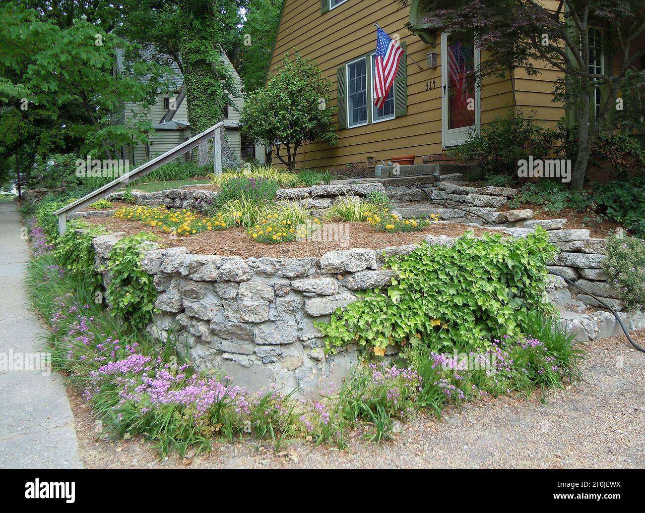 Irregular chunks of concrete form a retaining wall, steps and walkway ...