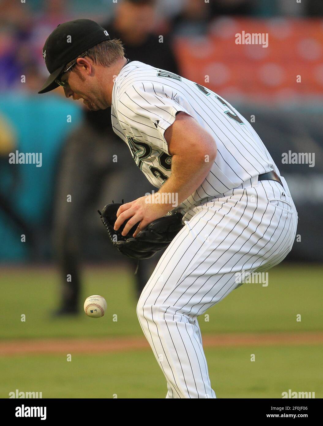 Florida Marlins pitcher Nate Robinson drops a bunt by Jeff Francis of ...