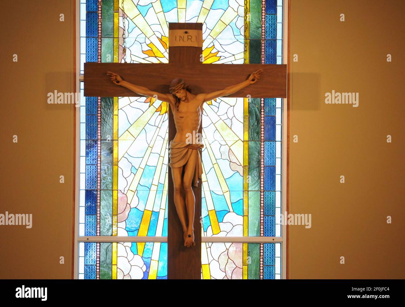 The crucifix hangs in front of a stained-glass window at Our Lady of ...