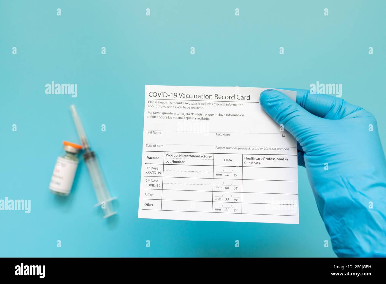 Doctor is holding a vaccination record card and corona virus vaccine ...