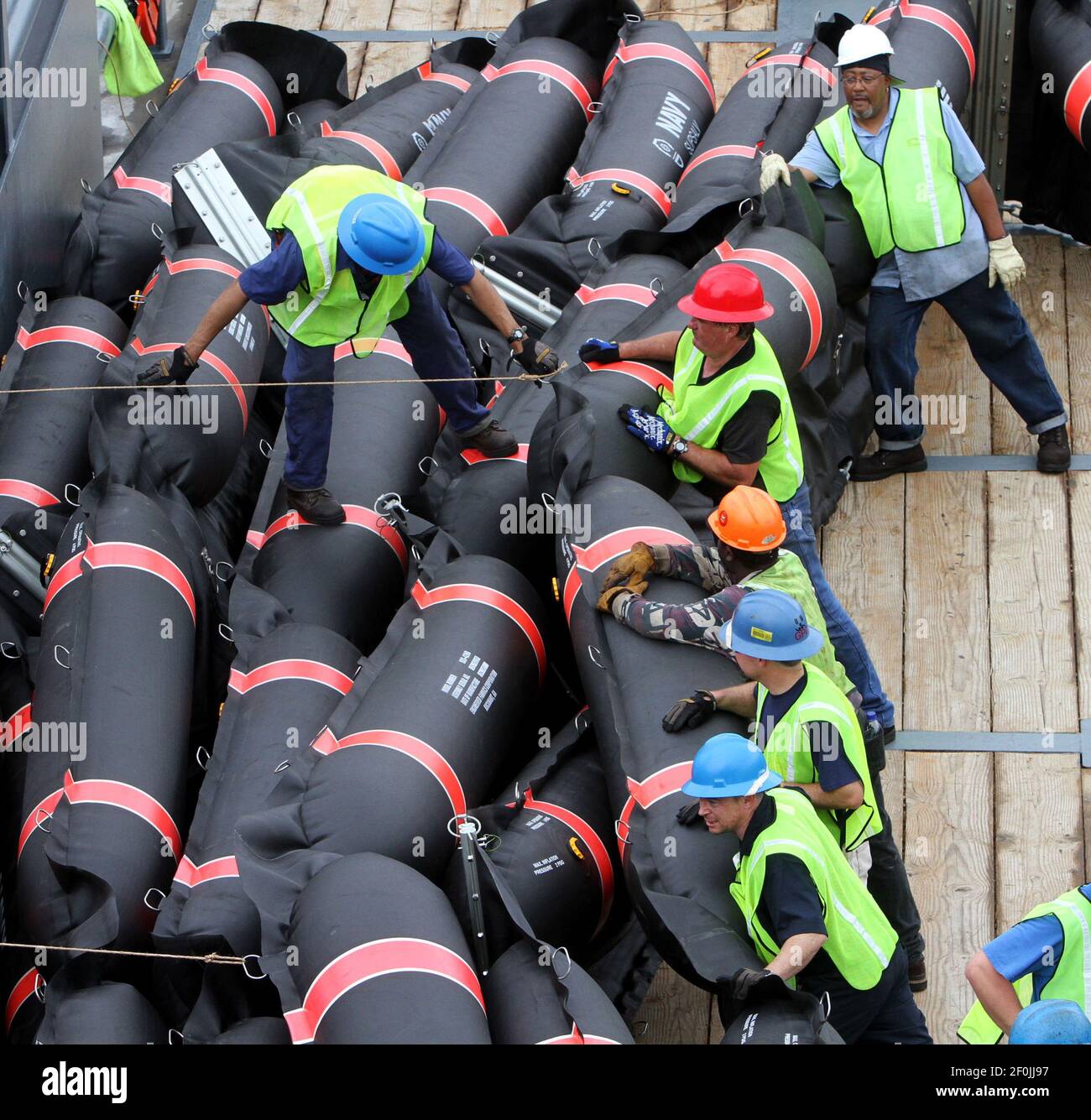 Workers secures inflatable oil containment booms on the deck of an ...