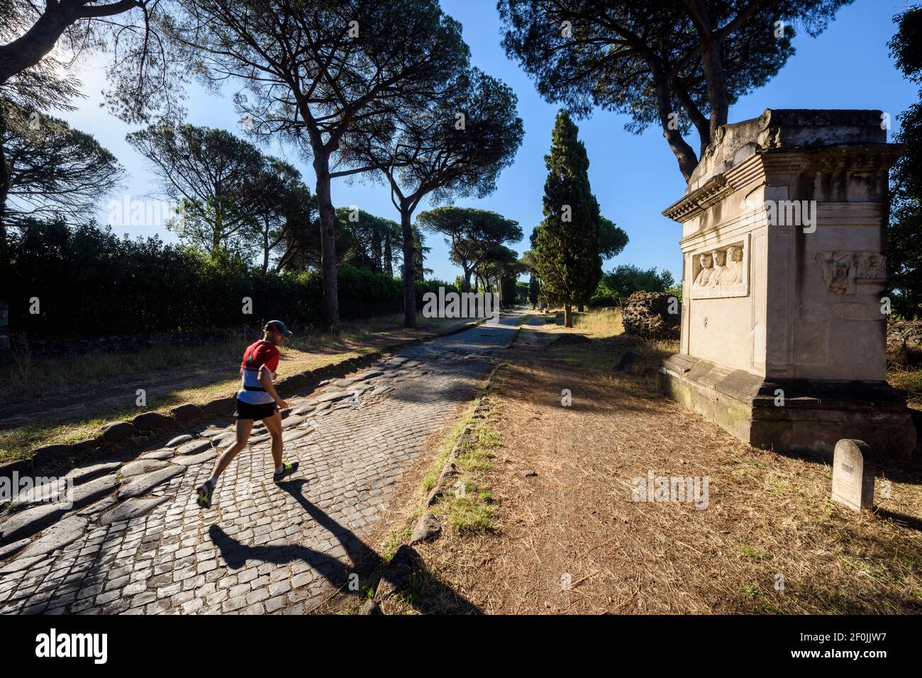 Rome. Italy. Running on the Via Appia Antica (Appian Way). Right, ancient Roman Tomb of the ...