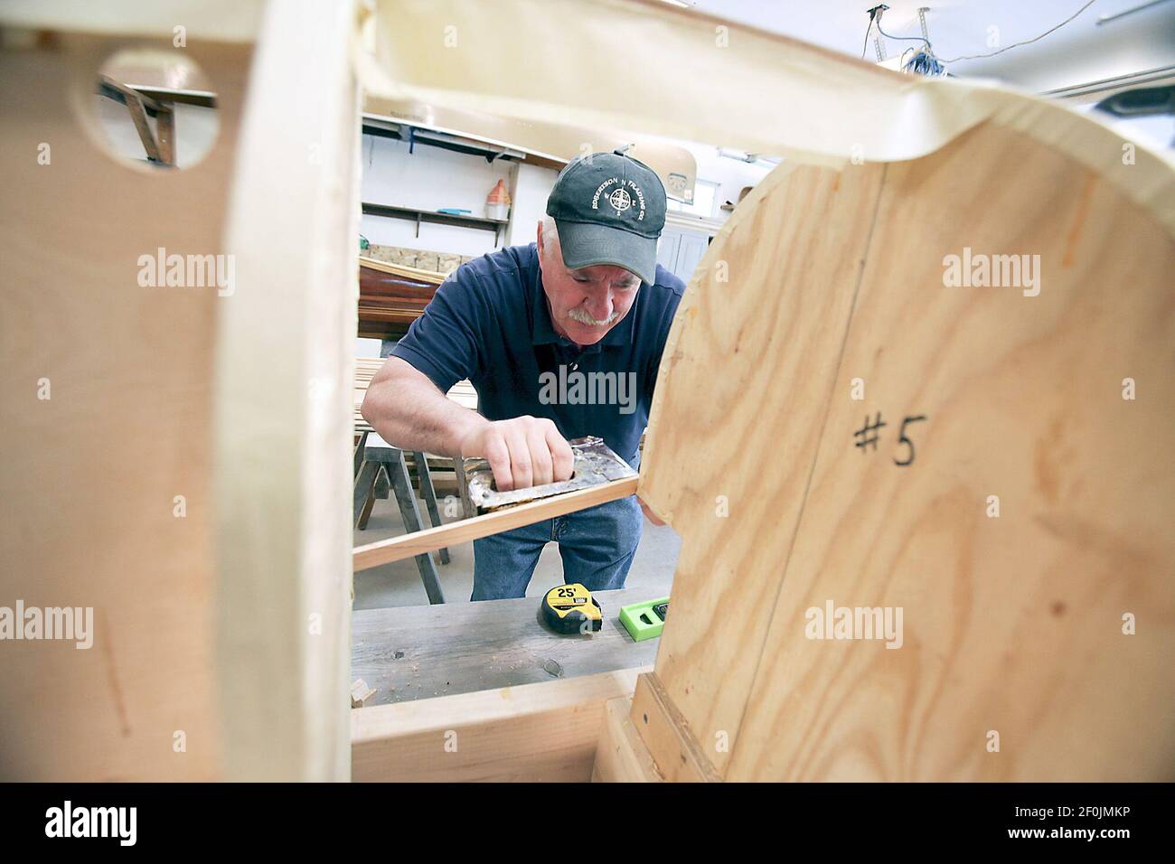Kevin Fredericks, of Cloquet, Minnesota, staples a piece of western red ...
