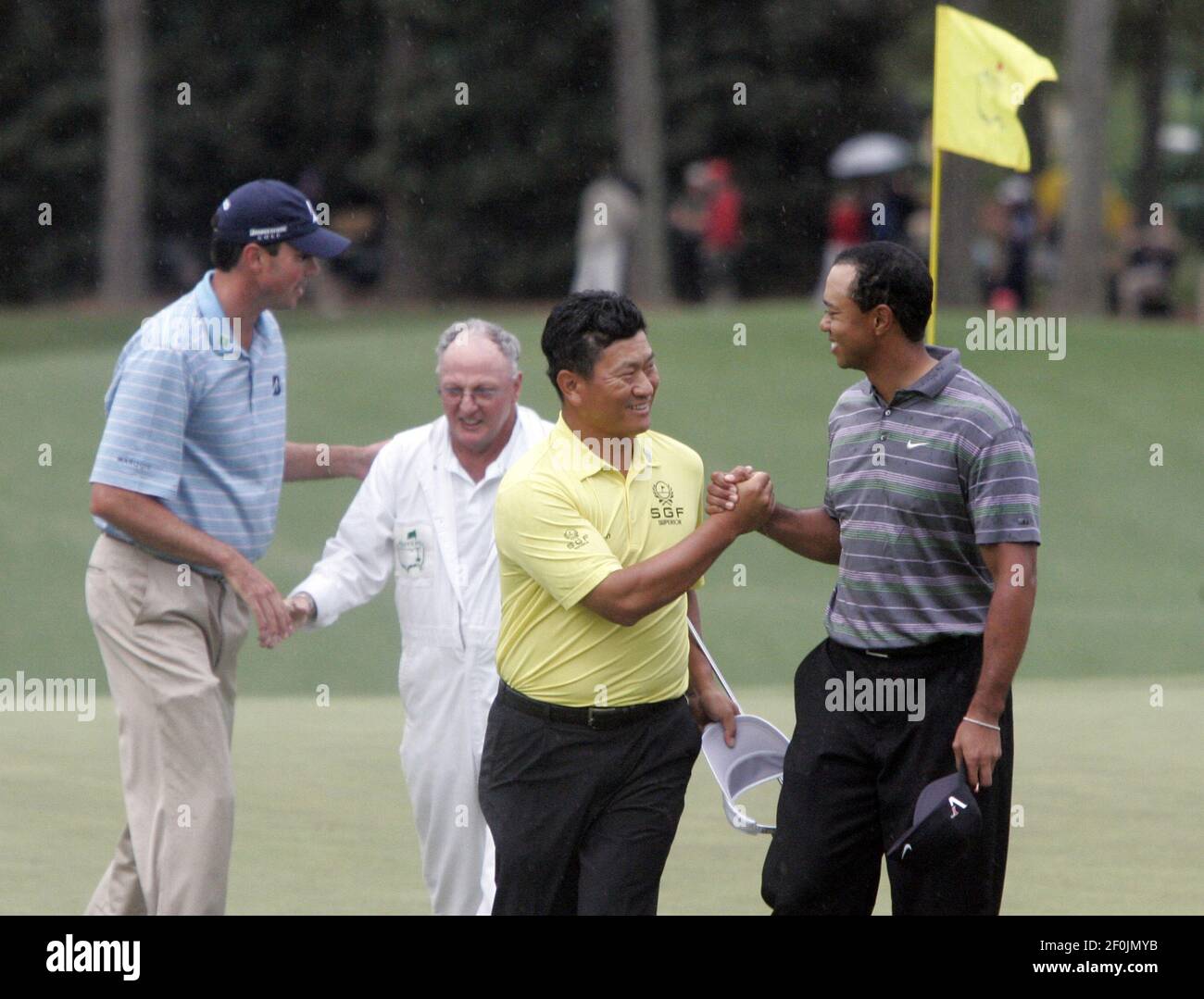 K.J. Choi and Tiger Woods (right) shake hands as they walk off the 18th ...